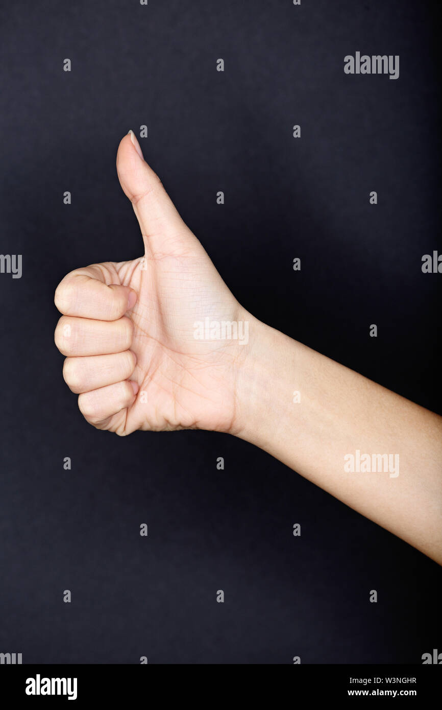 Thumbs up close up on black background. Female hand giving like hand ...