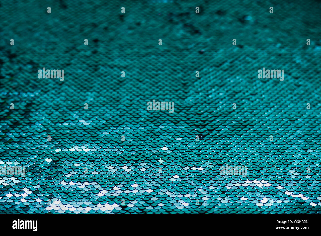 Shiny iridescent turquoise sequins on fabric. Abstract festive ...