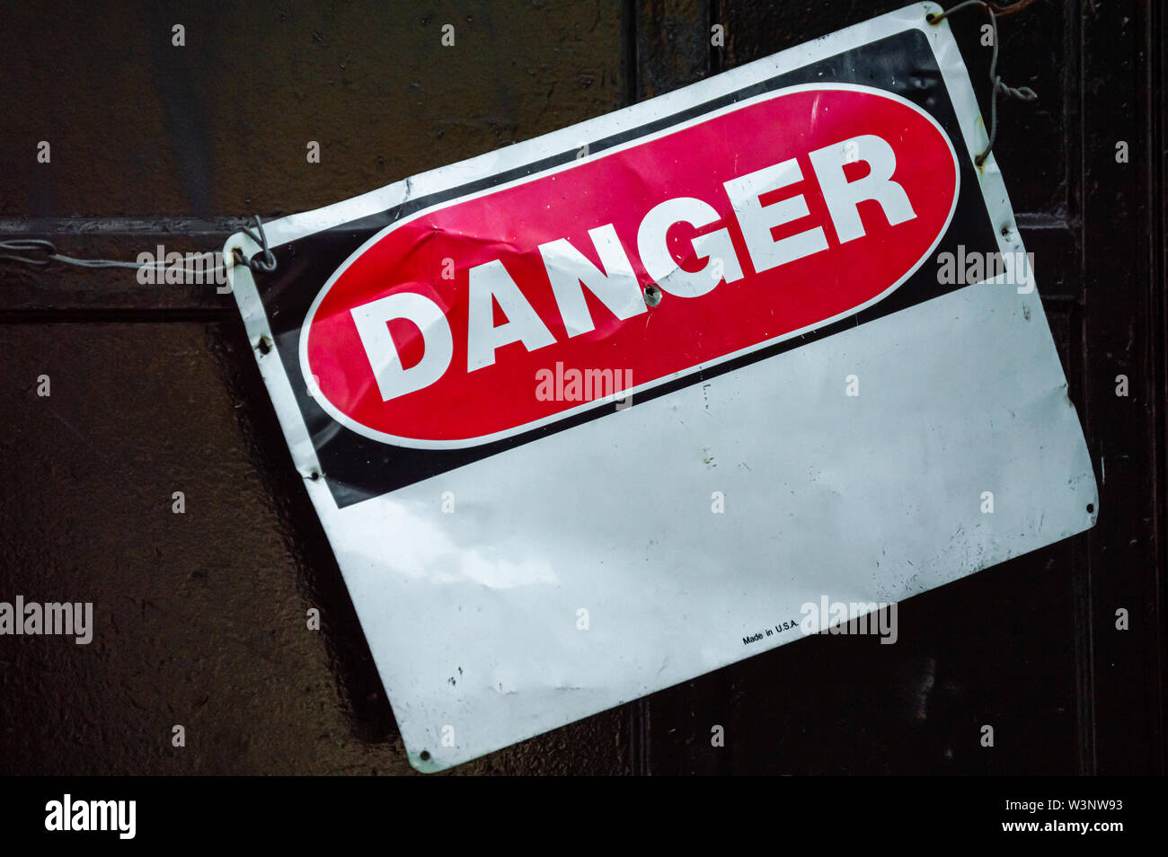 Crooked old metal warning sign that reads DANGER. Copy space. Graphic ...