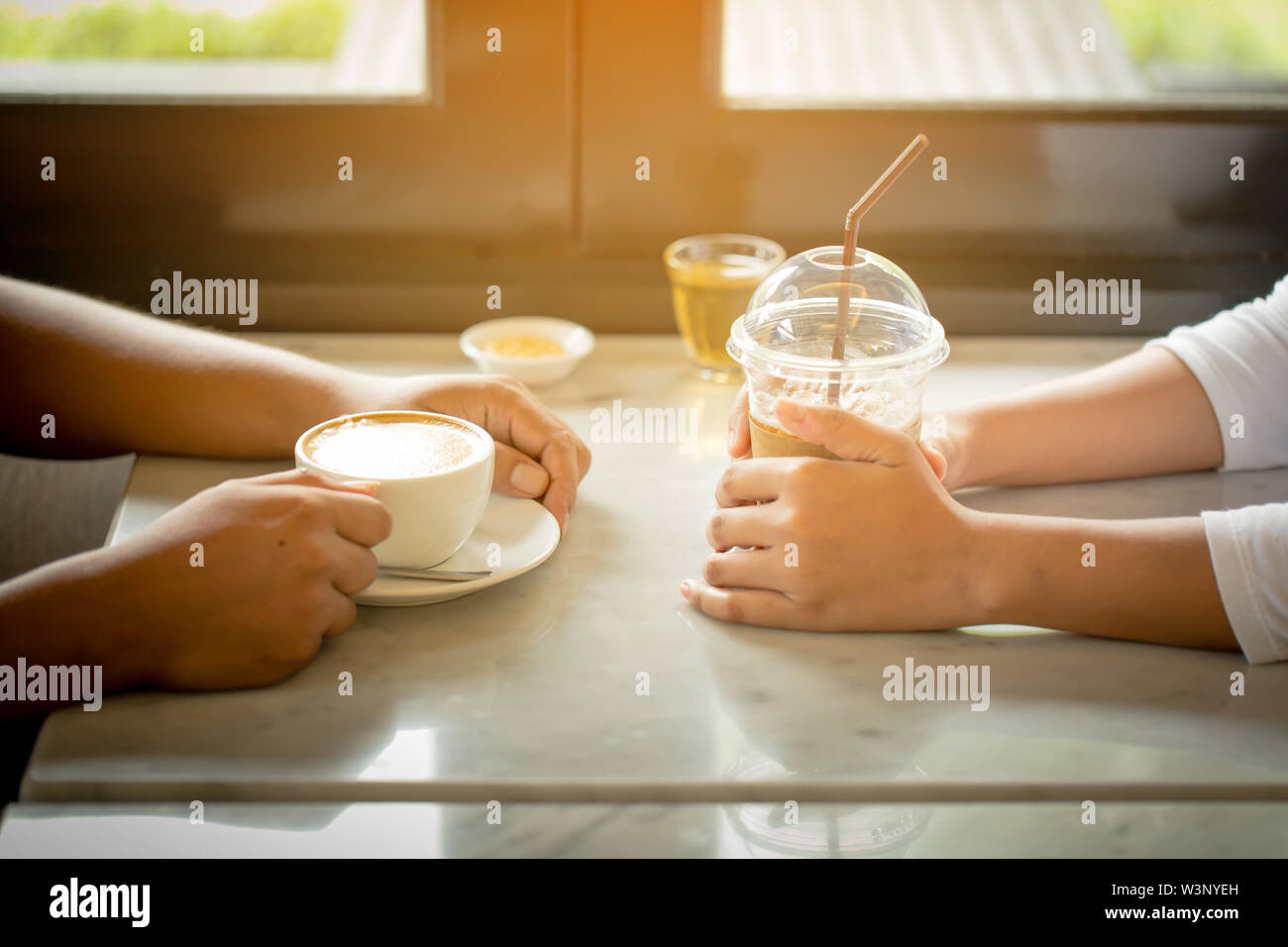 couple drinking hot and cold coffee Stock Photo - Alamy