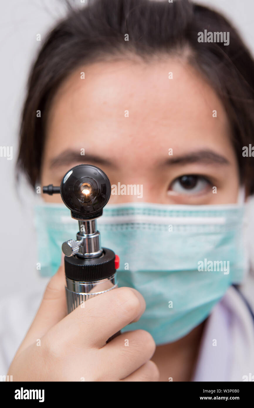 Doctor looks through otoscope instrument Stock Photo - Alamy