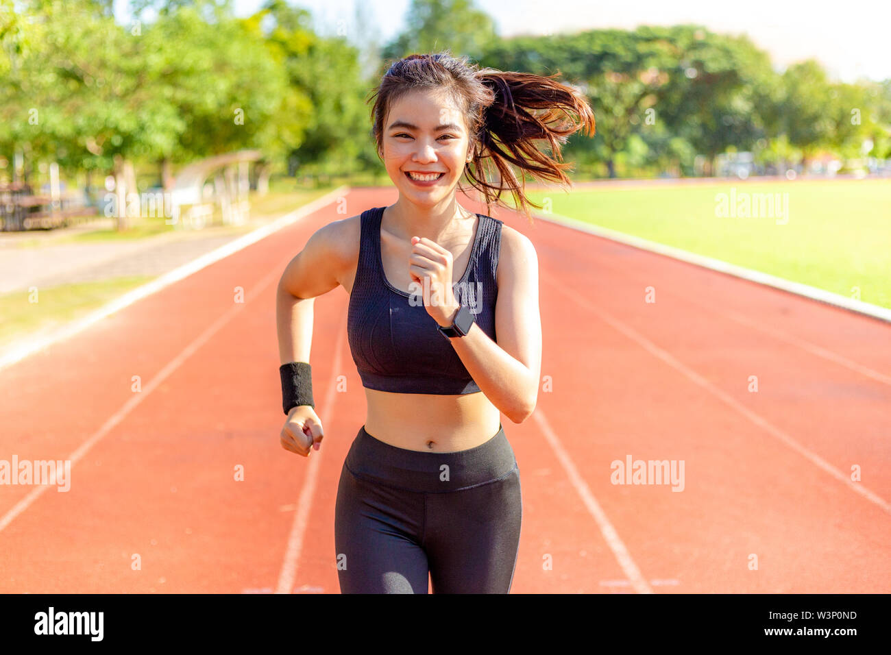 Beautiful happy young Asian woman running for her morning exercise at a ...