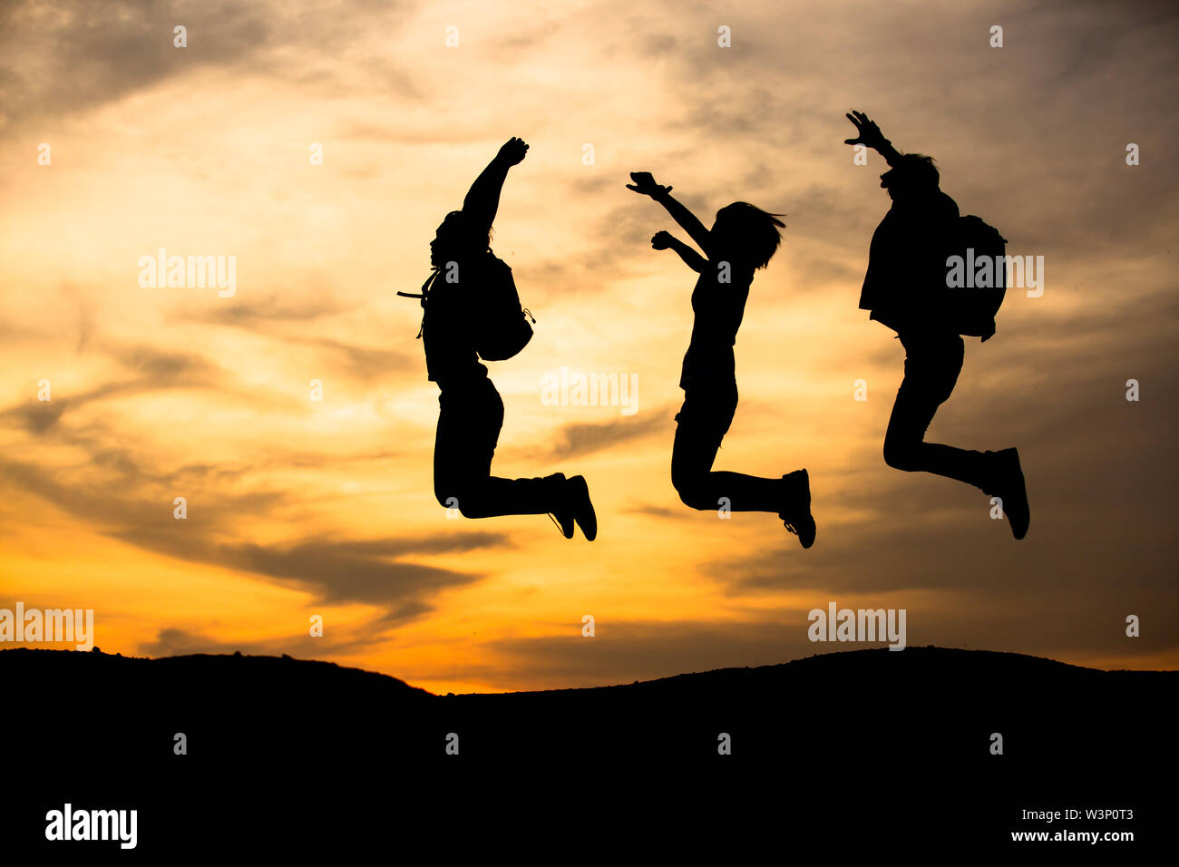 silhouette of friends jumping in sunset Stock Photo - Alamy
