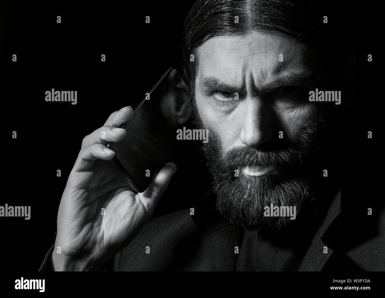strange bearded senior priest with a smartphone, bearded old man is ...
