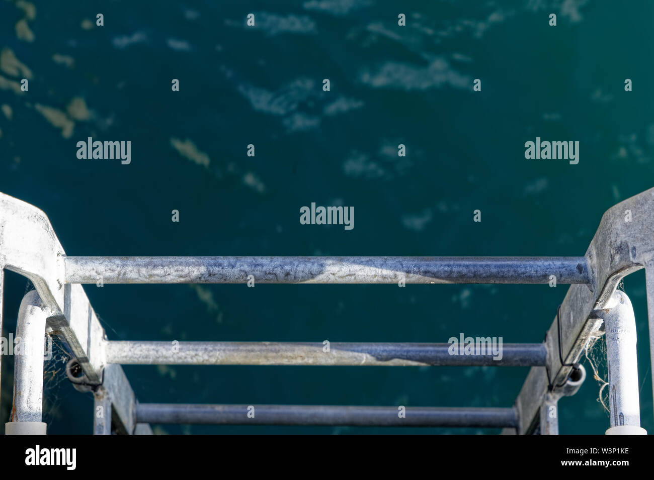 A steep ladder enters the blue water Stock Photo - Alamy
