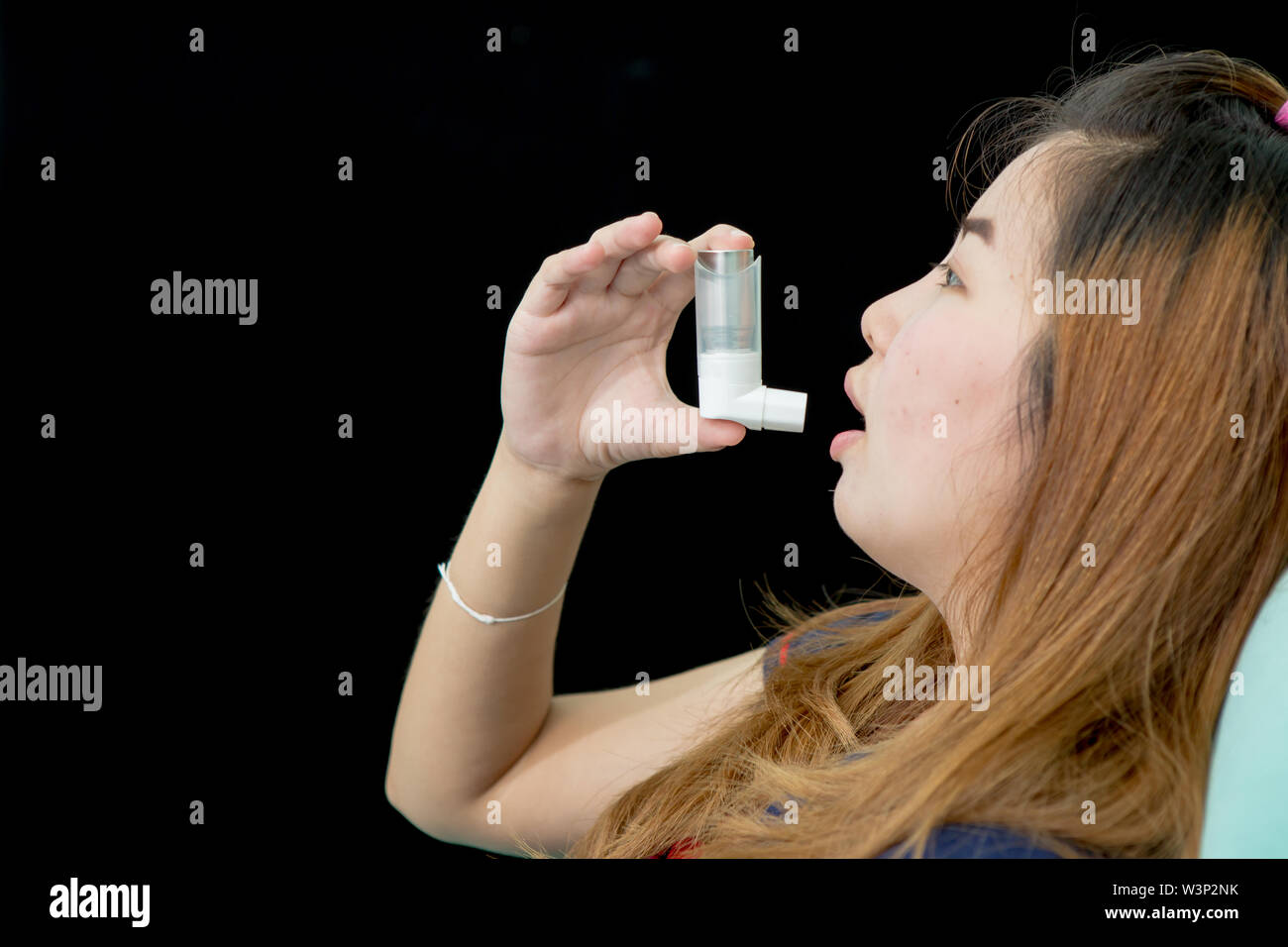 Asthma patient use inhaler spray on black background Stock Photo - Alamy