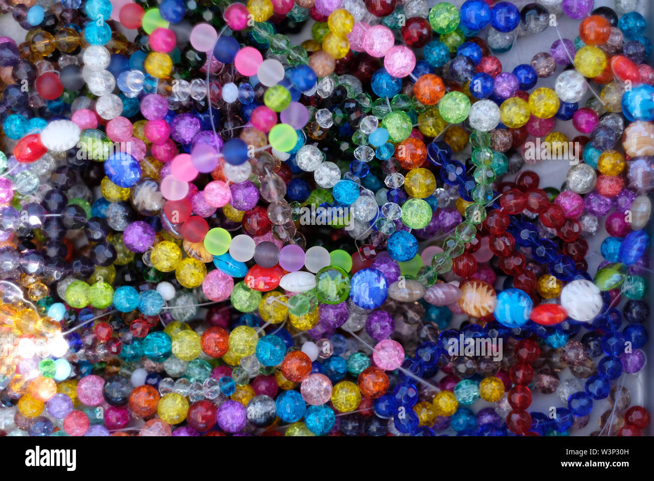 A scattering of colored glass beads on display Stock Photo - Alamy