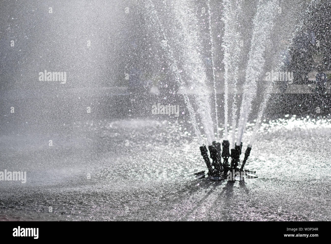Strong streams and splashes of water fountain in the middle of the pool ...