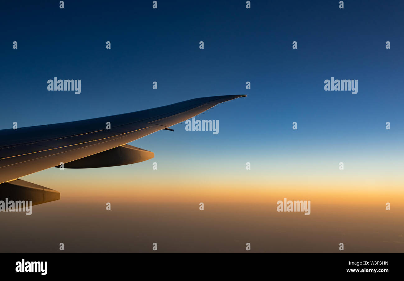 Wing of plane over the city. Airplane flying on blue sky. Scenic view ...