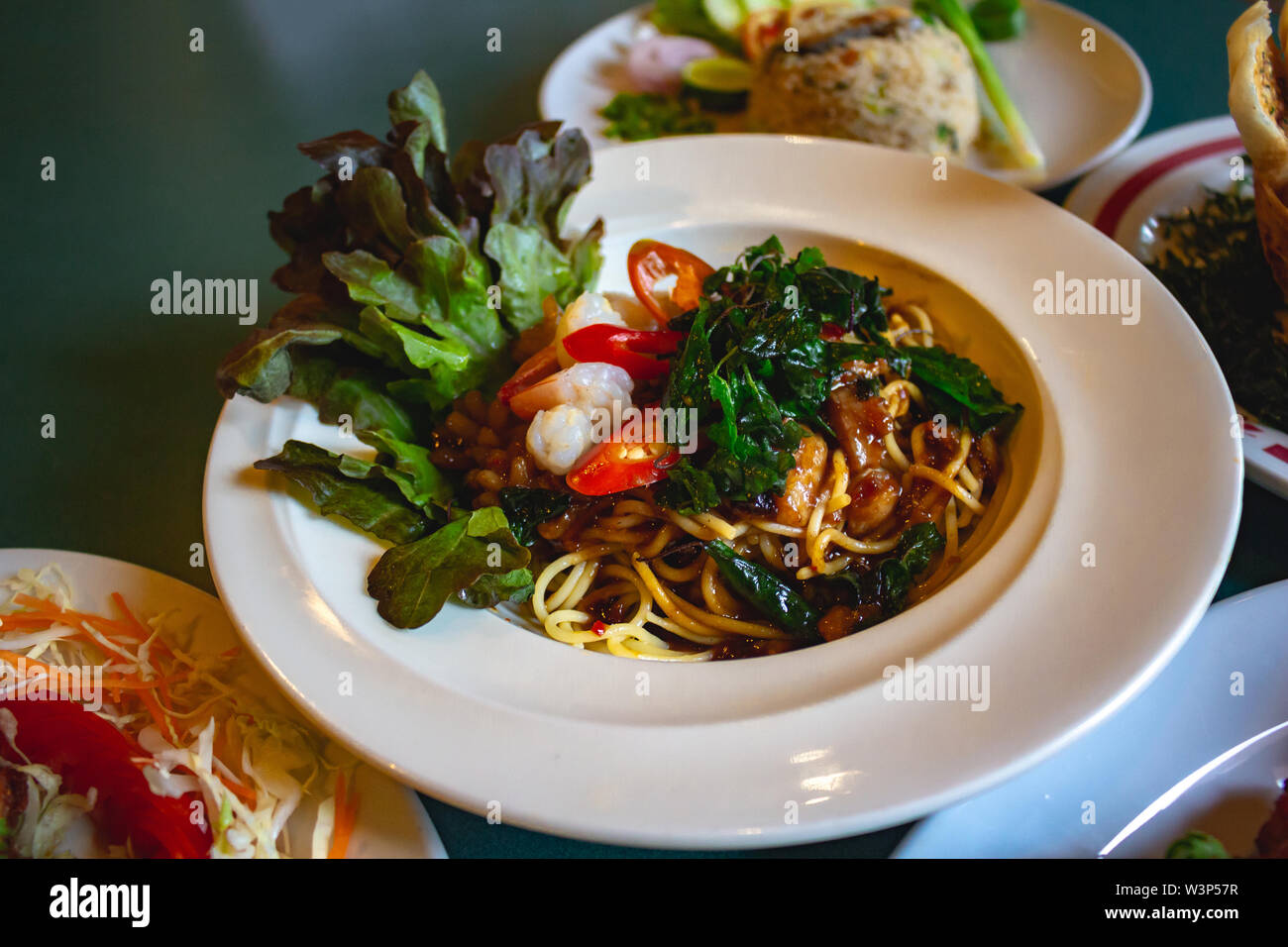 Spaghetti with chili seafood and hot basil leaves Stock Photo - Alamy