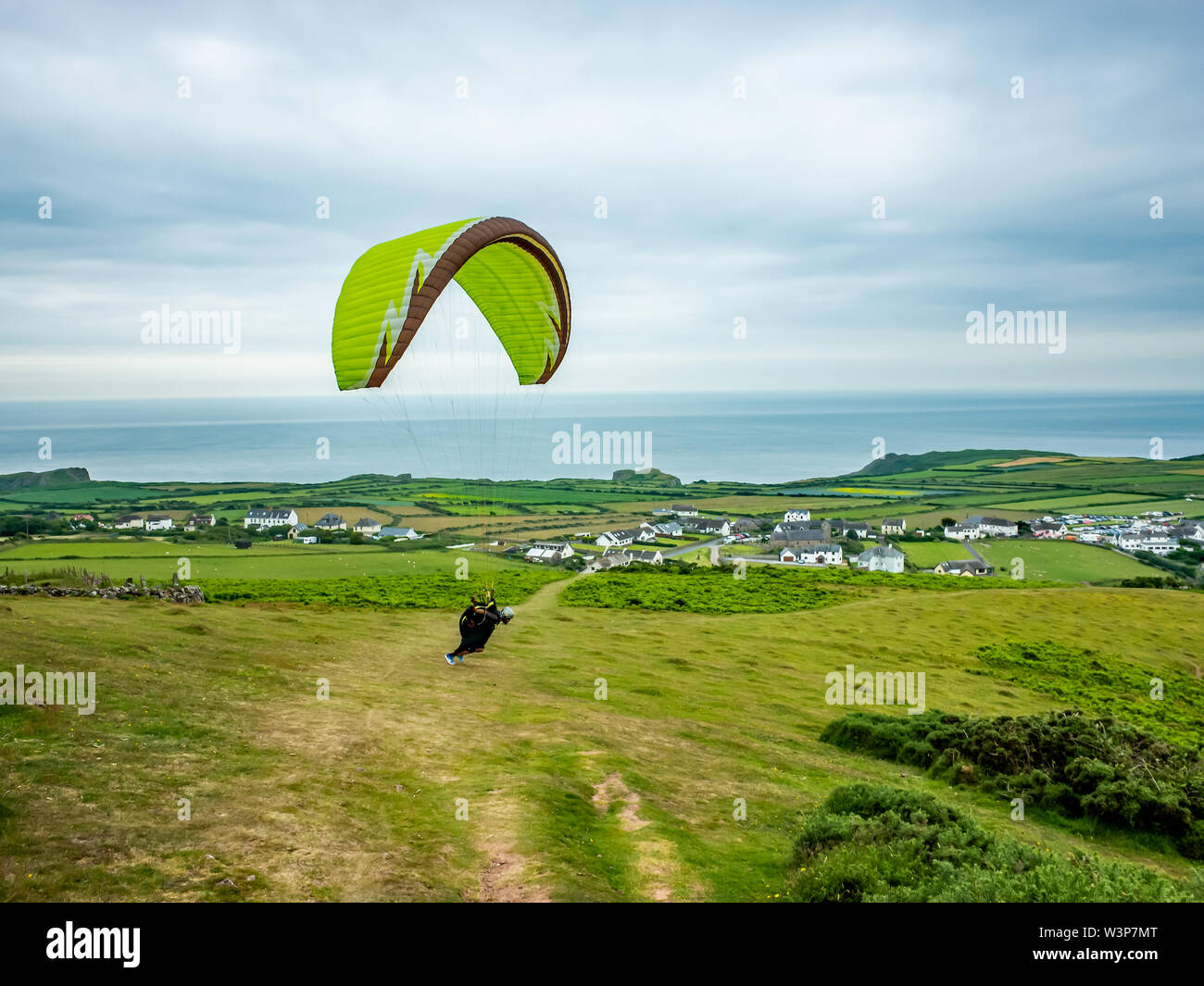 Paraglider on the cliff top of the Gower Way above Rhossili Bay ...