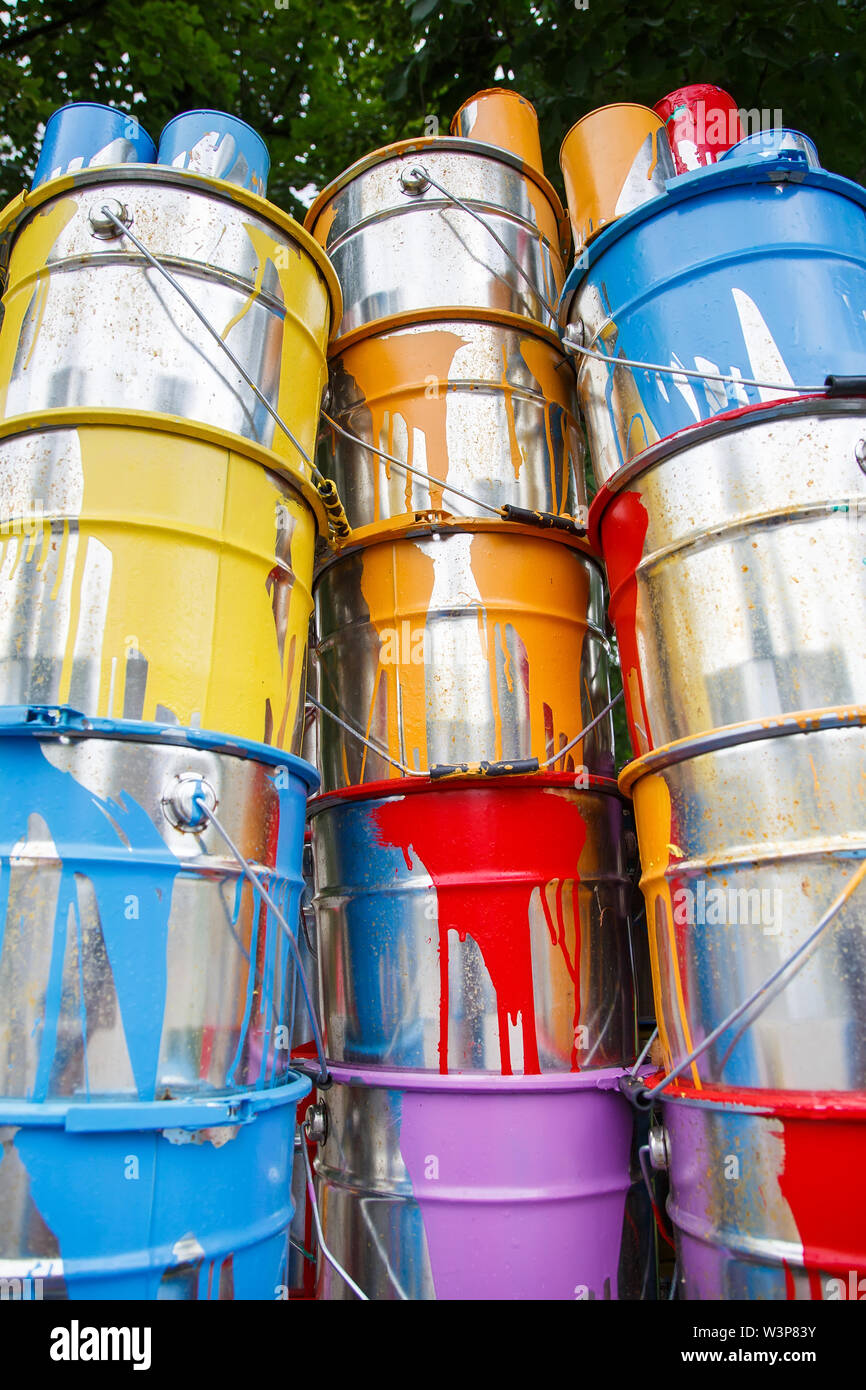 The used paint cans. Many multi-colored buckets with traces of paint on ...