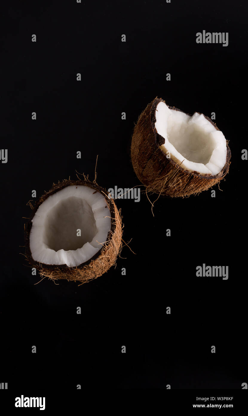 Flying fresh coconut at black background. Levitation of cracked coconut ...