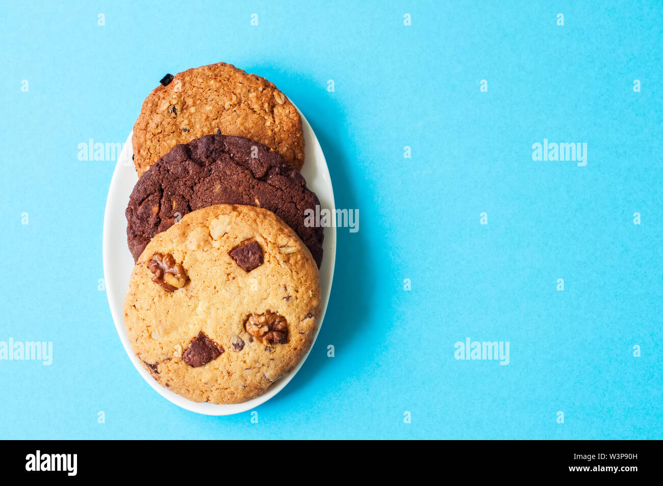 Three types of cookies in a plate on a blue background. Copy space ...