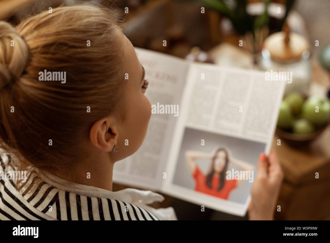 Helpful articles. Focused blonde client attentively reading article on ...