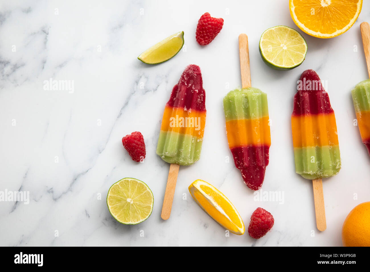 Summer fruit ice lollies made with orange lime and raspberries Stock ...
