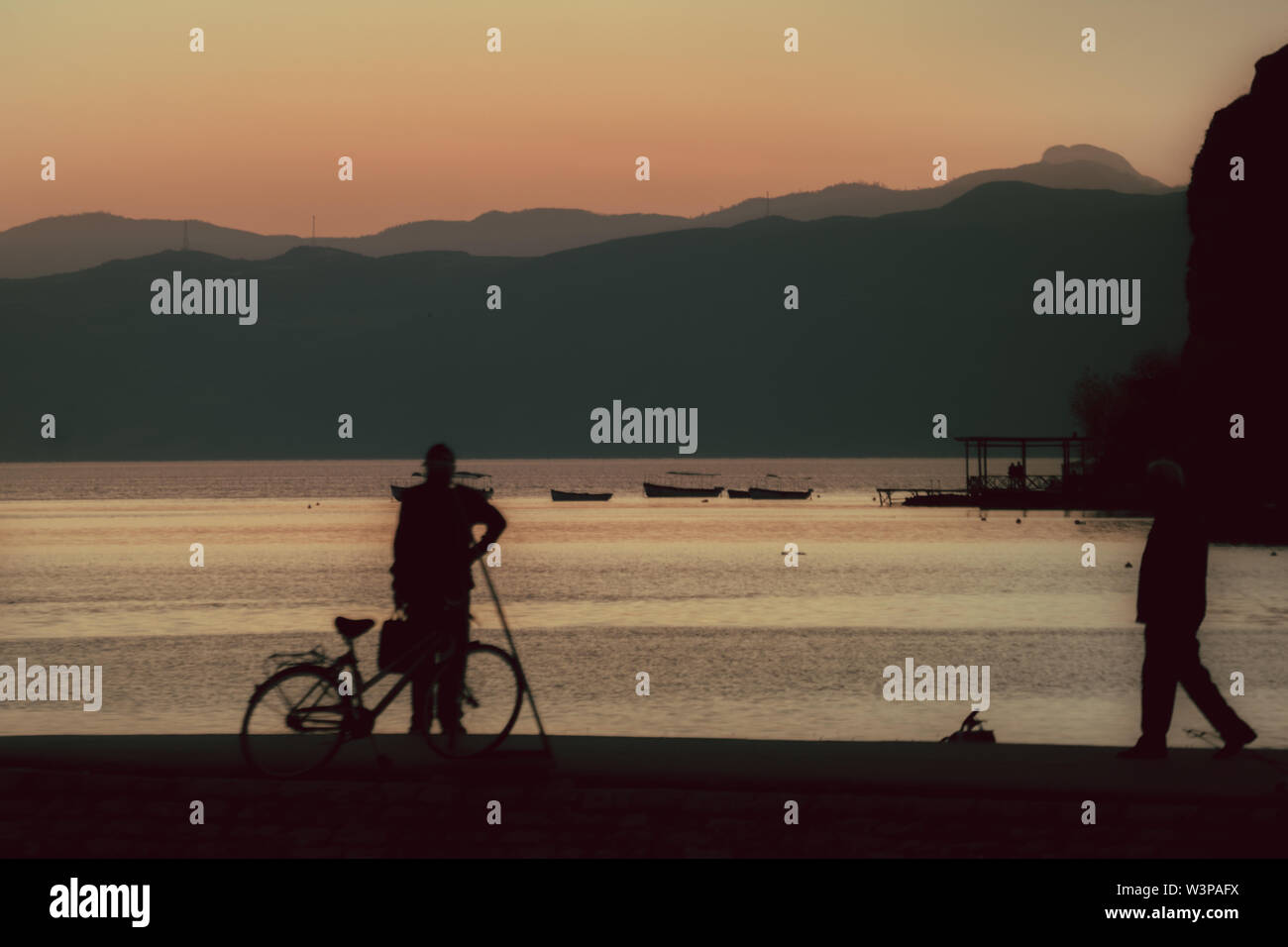 People on the shore during sunset over stunningly beautiful Lake Ohrid ...