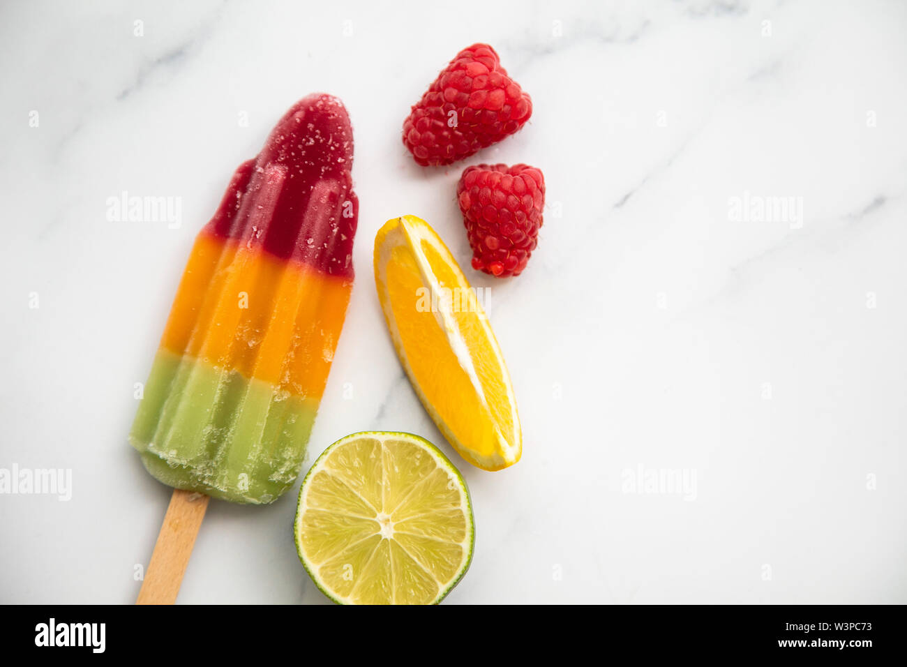 Summer fruit ice lollies made with orange lime and raspberries Stock ...