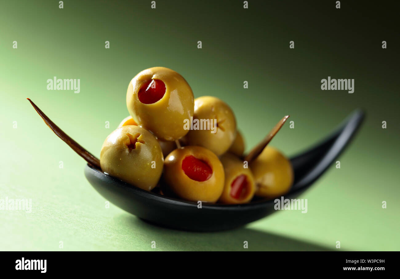 Appetizing olives stuffed with red pepper in small black bowl Stock ...
