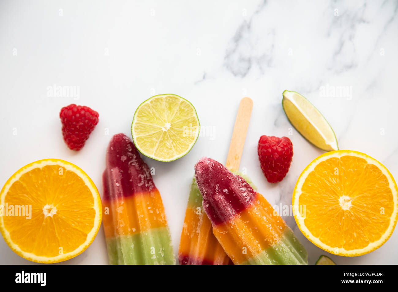 Summer fruit ice lollies made with orange lime and raspberries Stock ...