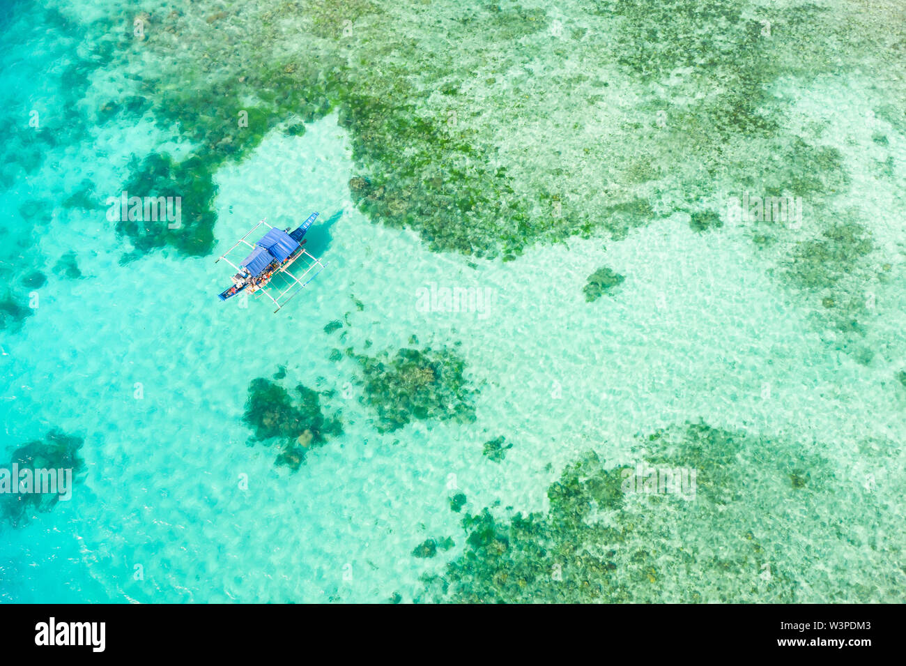 Boat on a coral reef. Sea surface with an atoll, coral reefs. Sea shoal ...