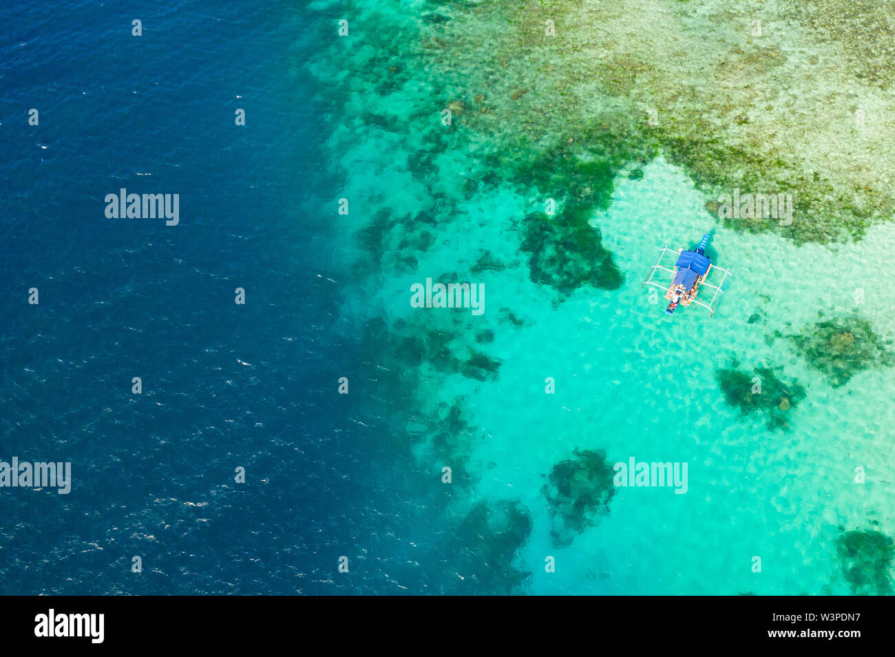 Boat on a coral reef. Sea surface with an atoll, coral reefs. Sea shoal ...