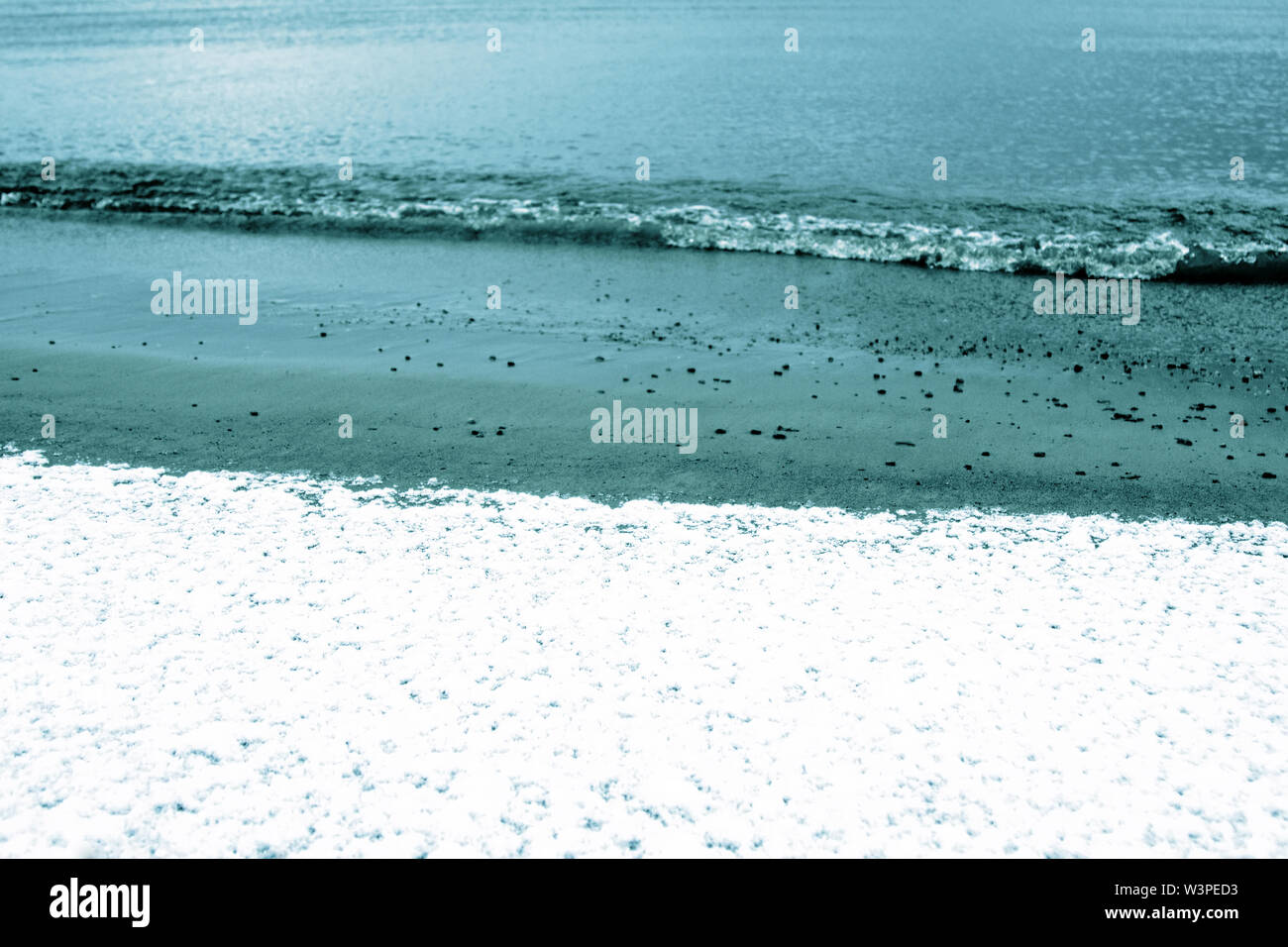 Onset of winter. The first snow on the beach. Waves lick the frost on ...