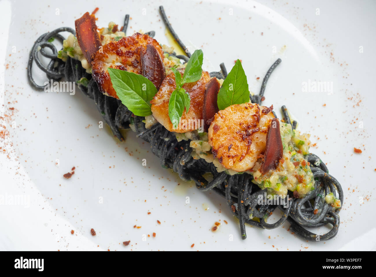 close up of tagliolini squid black ink pasta scallop seafood sauce ...