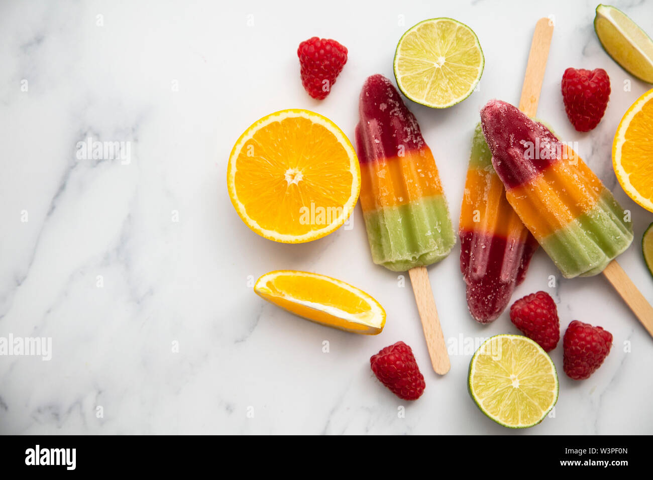 Summer fruit ice lollies made with orange lime and raspberries Stock ...