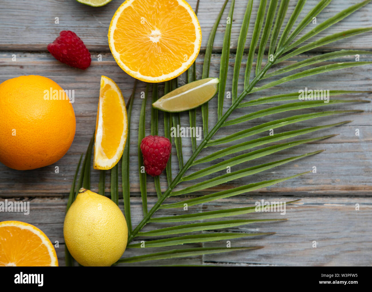 Creative fruits flat lay. Orange, lime and raspberry on the wooden ...
