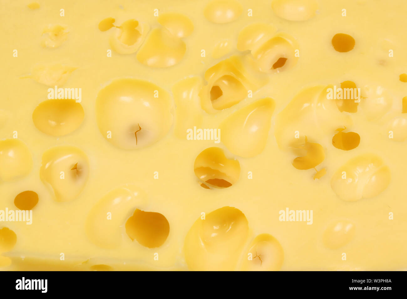 Edamer cheese background - yellow cheese with holes Stock Photo - Alamy