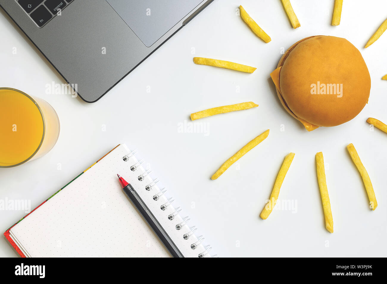 Fast food at work snacking. Laptop, hamburger and french fry at ...