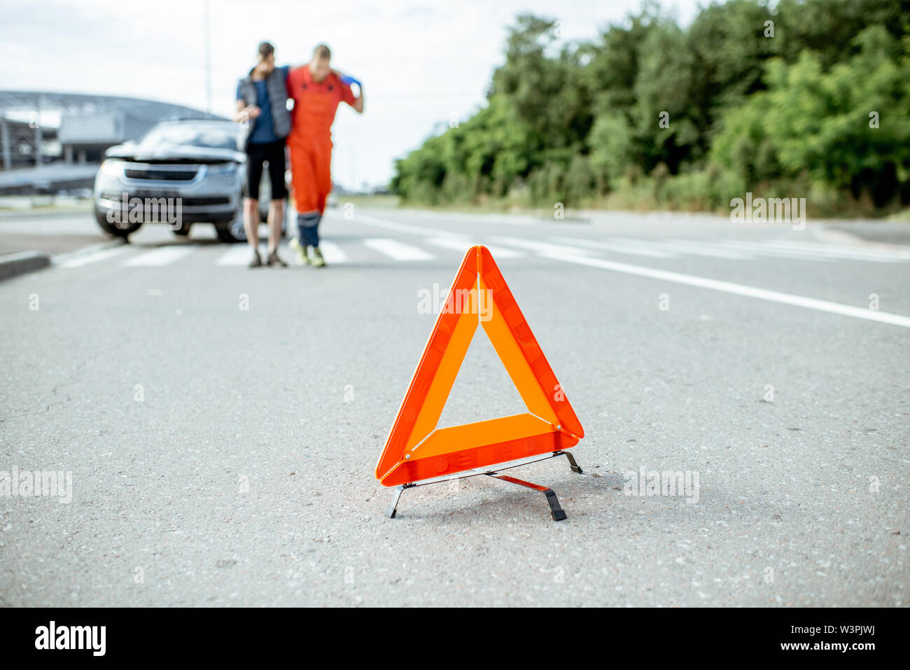 Medic in uniform helping injured man to walk, applying first aid after ...