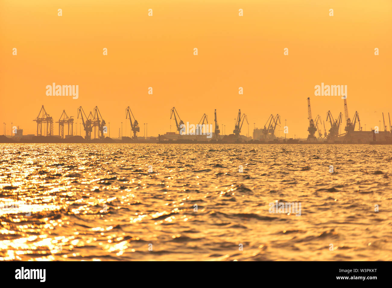 Heavy industrial port equipment, big cranes in sunset lightw Stock ...