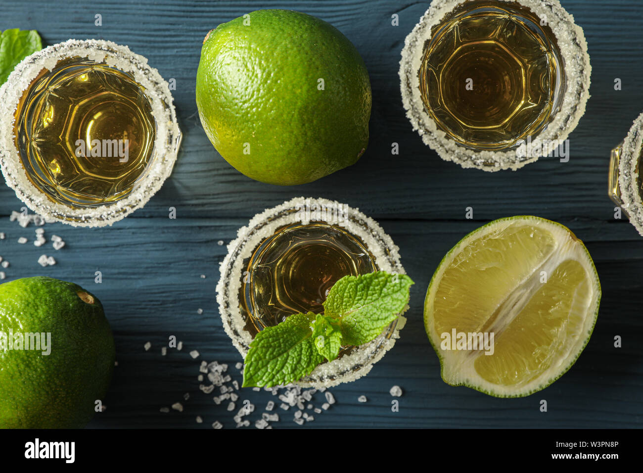 Flat lay composition with tequila shots, salt, lime slices and mint on ...
