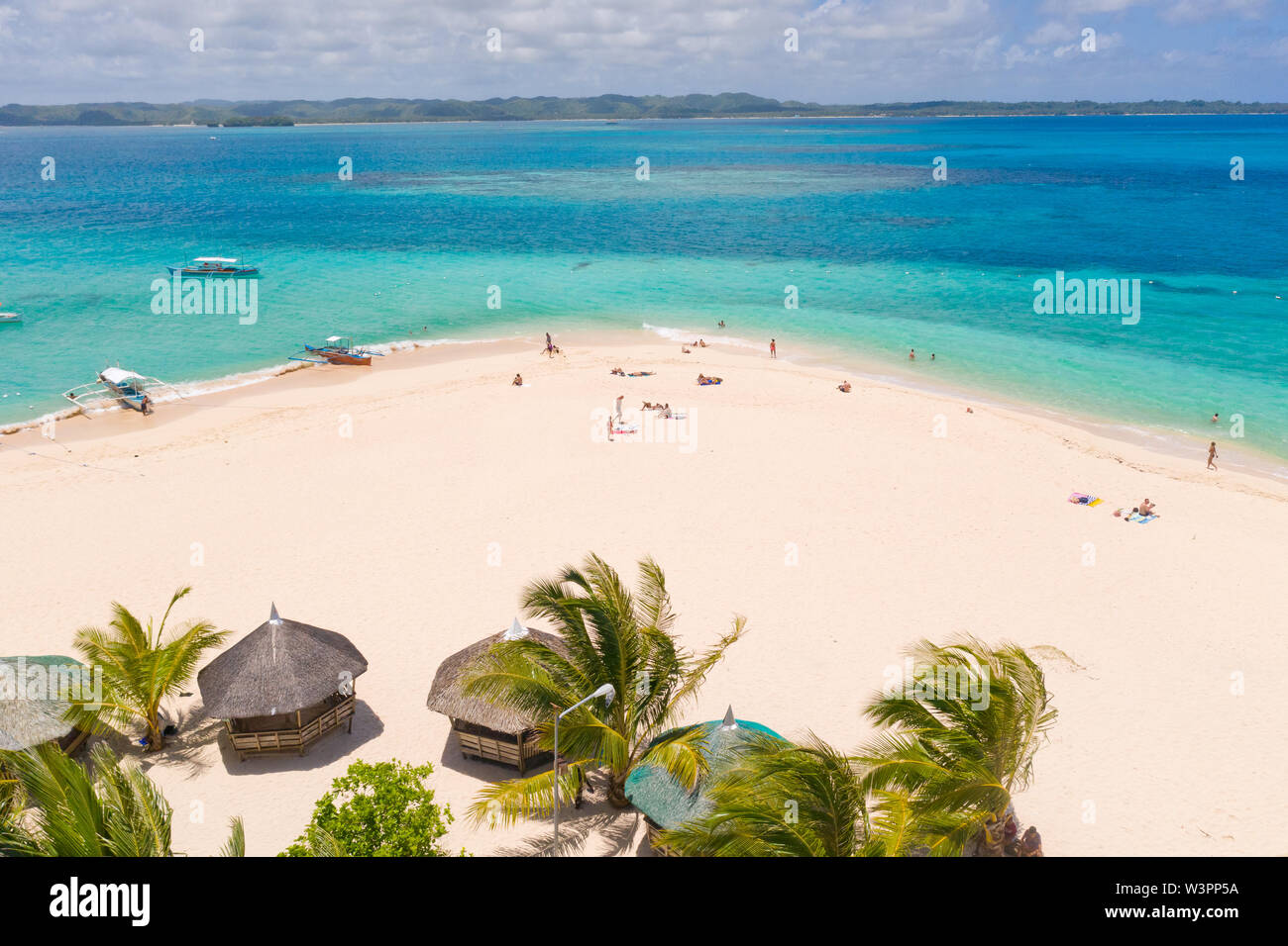 Daco island, Philippines. Palm trees and bungalows on the white sandy ...