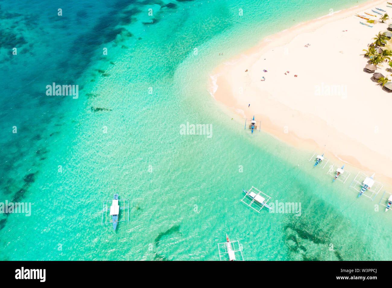 Daco island, Philippines. Palm trees and bungalows on the white sandy ...