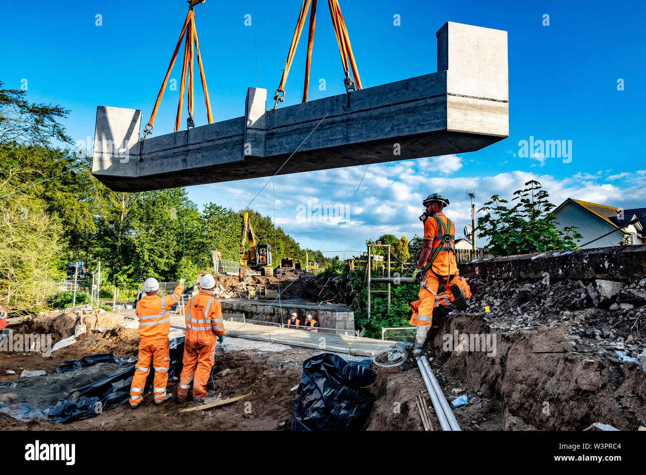 Railway workers constructing railway and lifting rail bridge into place ...