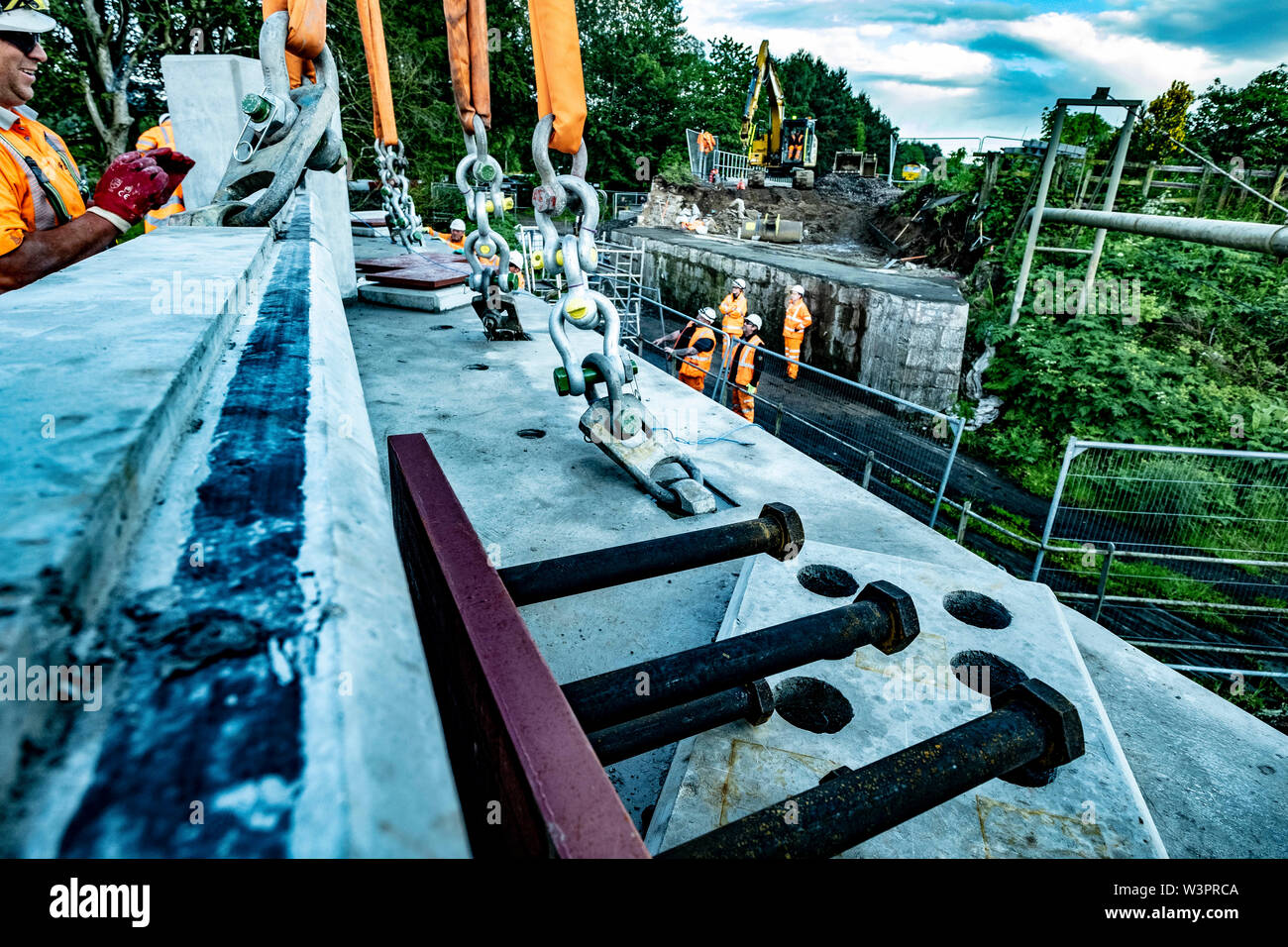 Railway workers constructing railway and lifting rail bridge into place ...