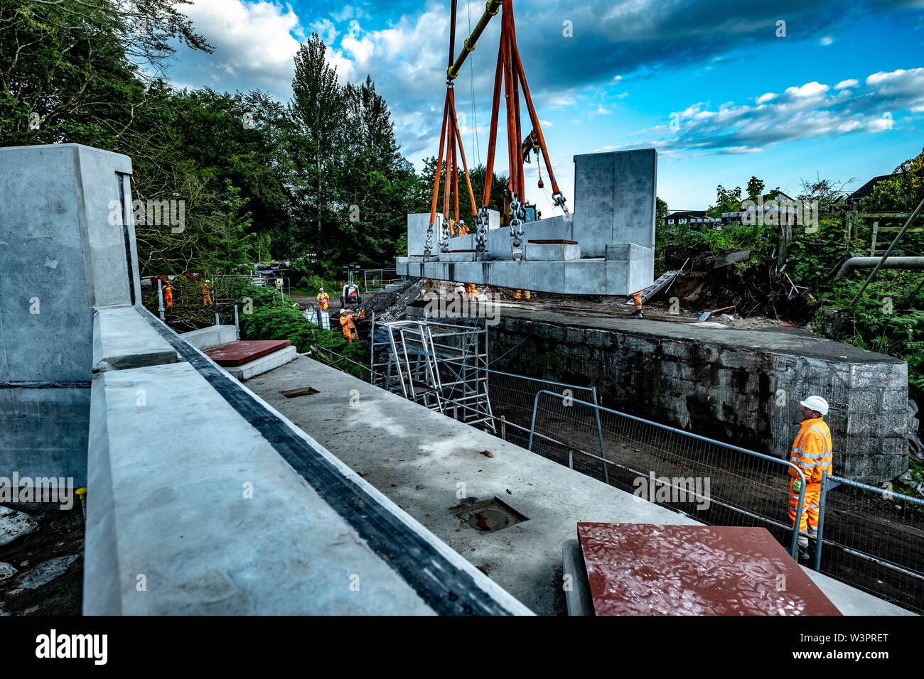 Railway workers constructing railway and lifting rail bridge into place ...