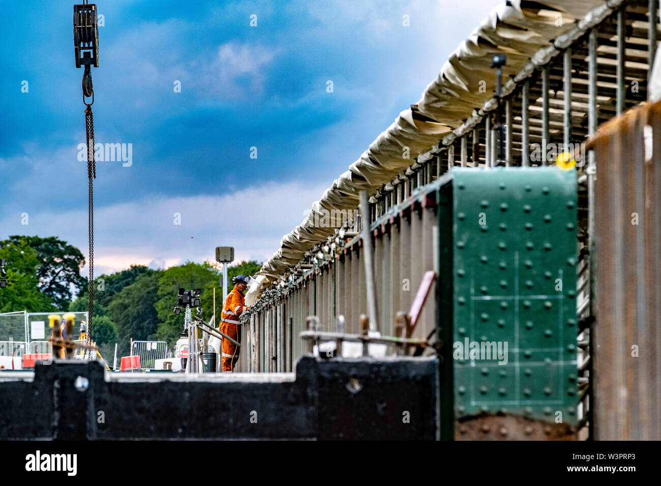 Railway workers constructing railway and lifting rail bridge into place ...