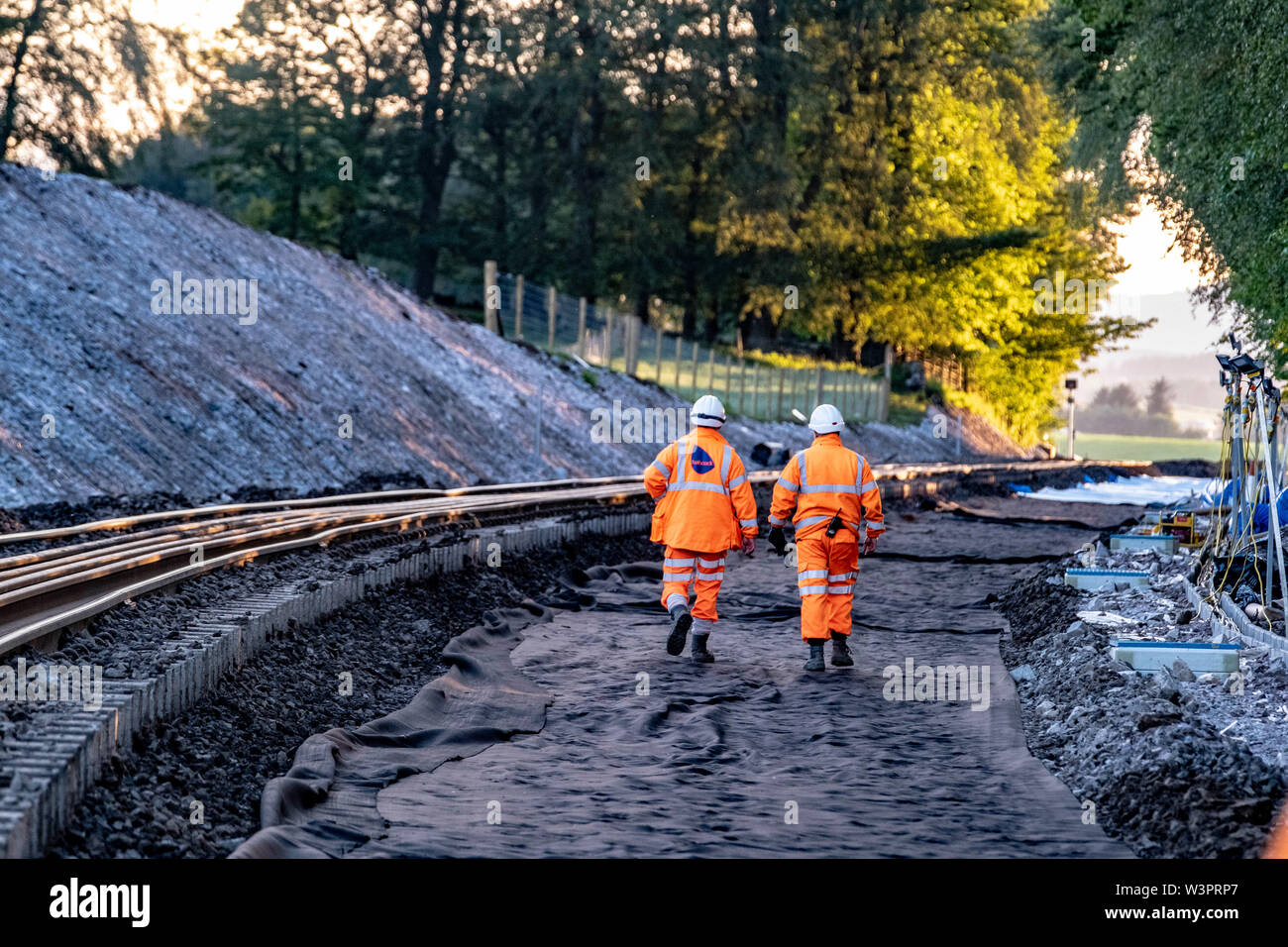 Railway workers constructing railway and lifting rail bridge into place ...