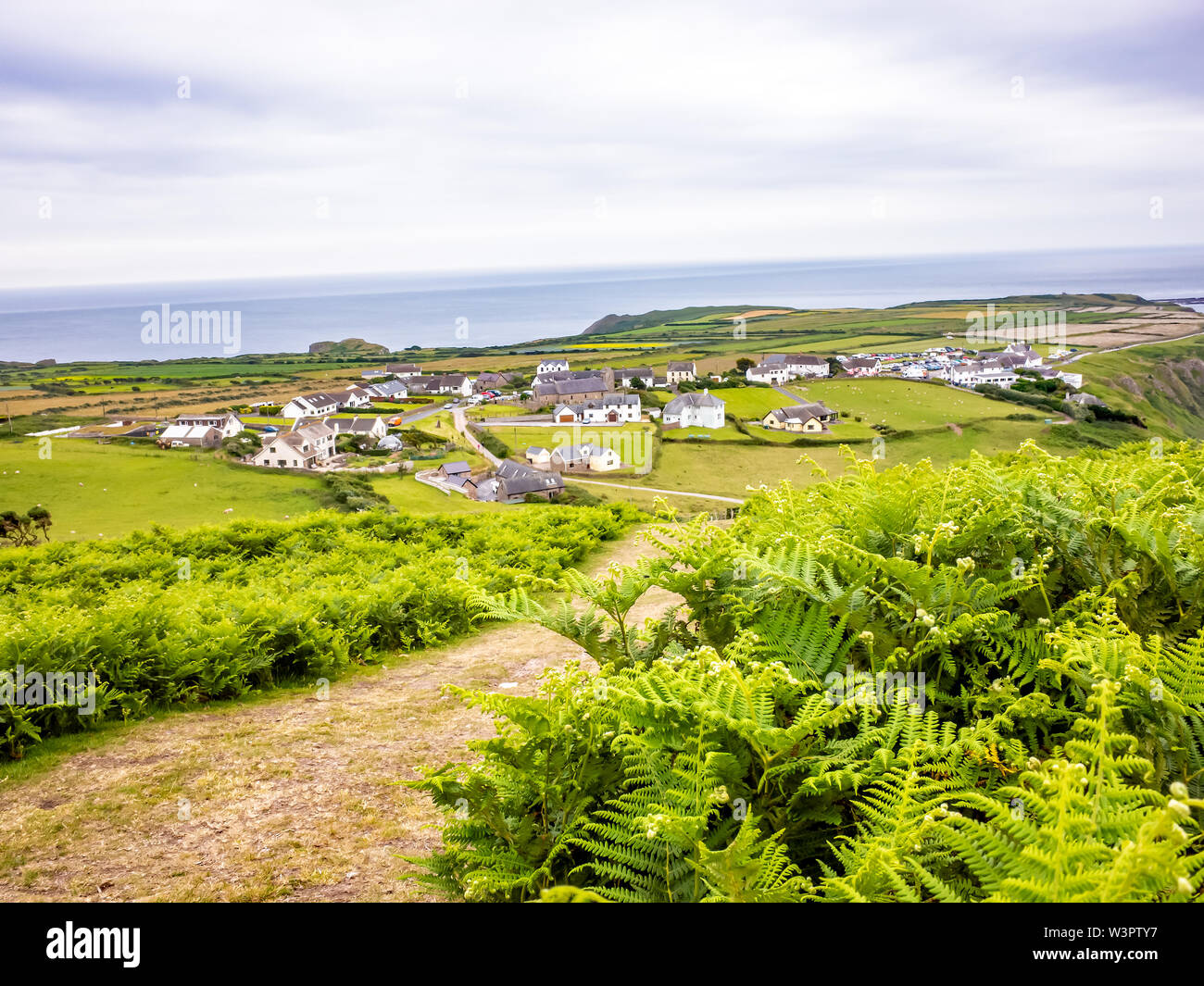 View from the hills of the Gower Way with the coastal village of ...