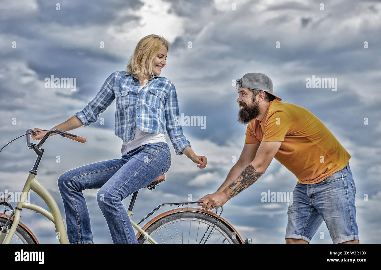 Support and friendship. Woman rides bicycle sky background. Service and ...