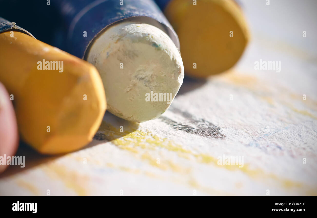 Oil pastel in crayons of different colors - yellow, ochre and white ...