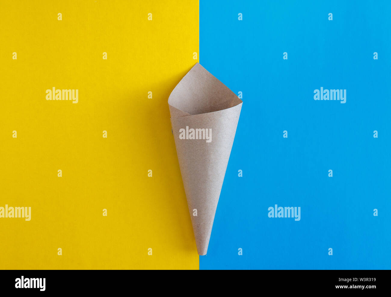 paper craft blank cone on blue and yellow background. top view. Flat ...