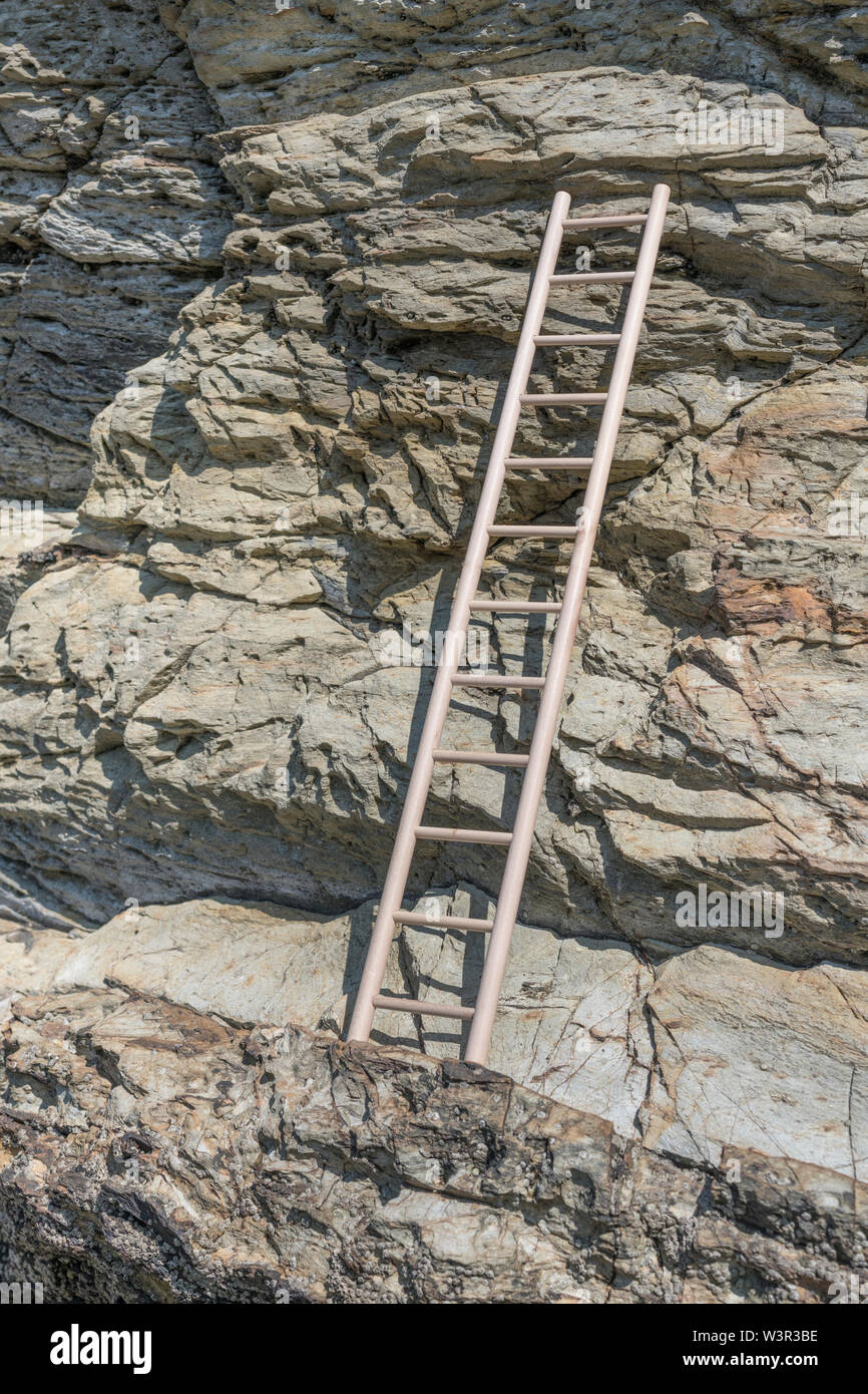 Small wood toy ladder propped against cliff face. Metaphor climbing ...
