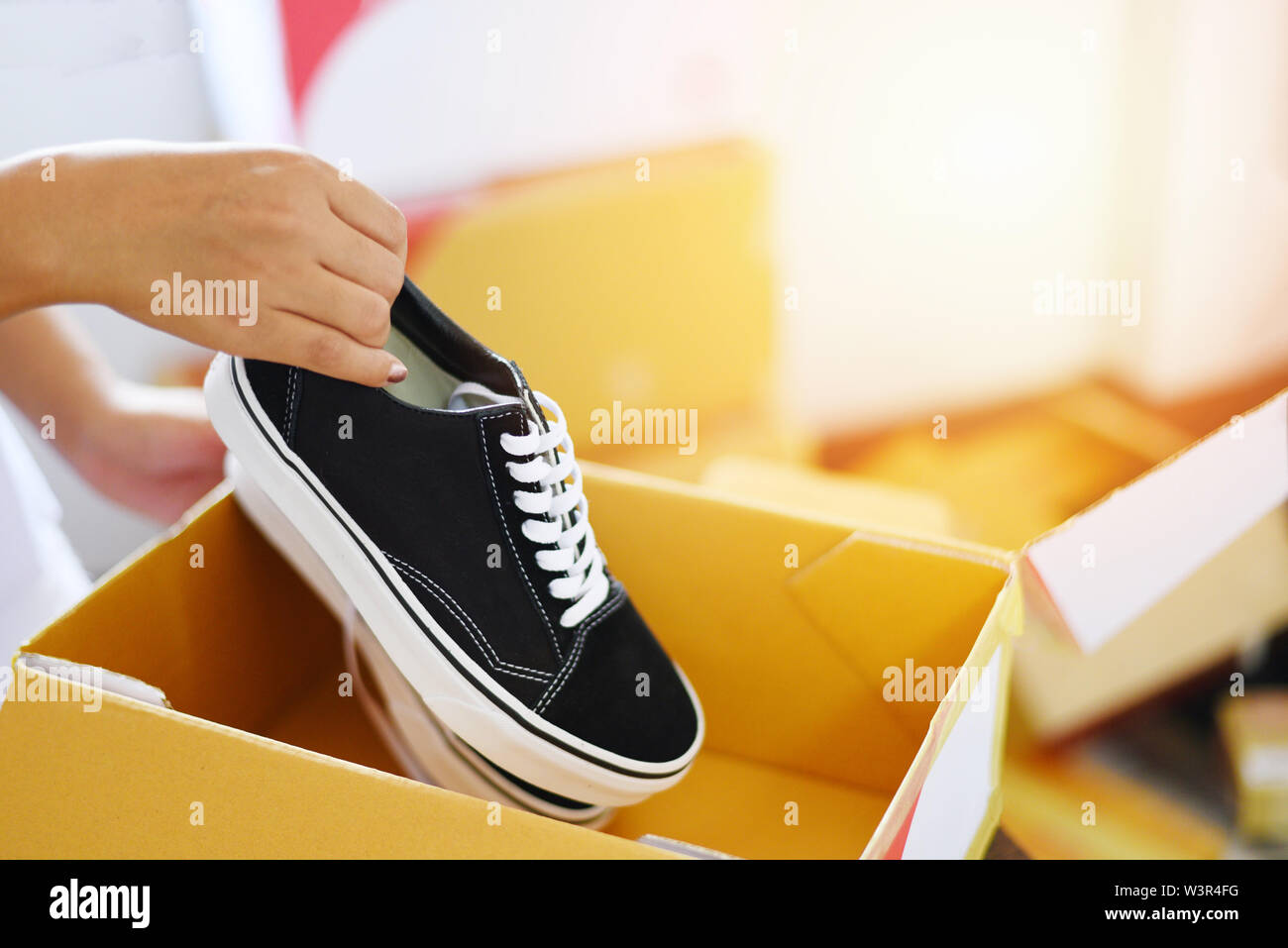 Selling online shopping / Woman packing shoes sneakers in cardboard box ...
