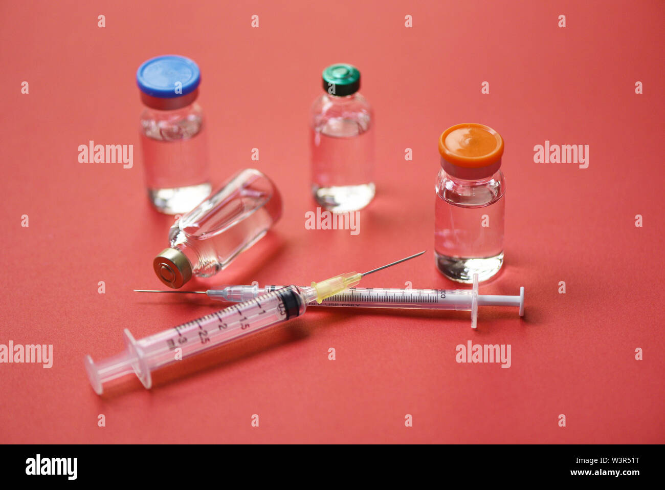 Medicine bottles glass for syringe injection needle on red background ...