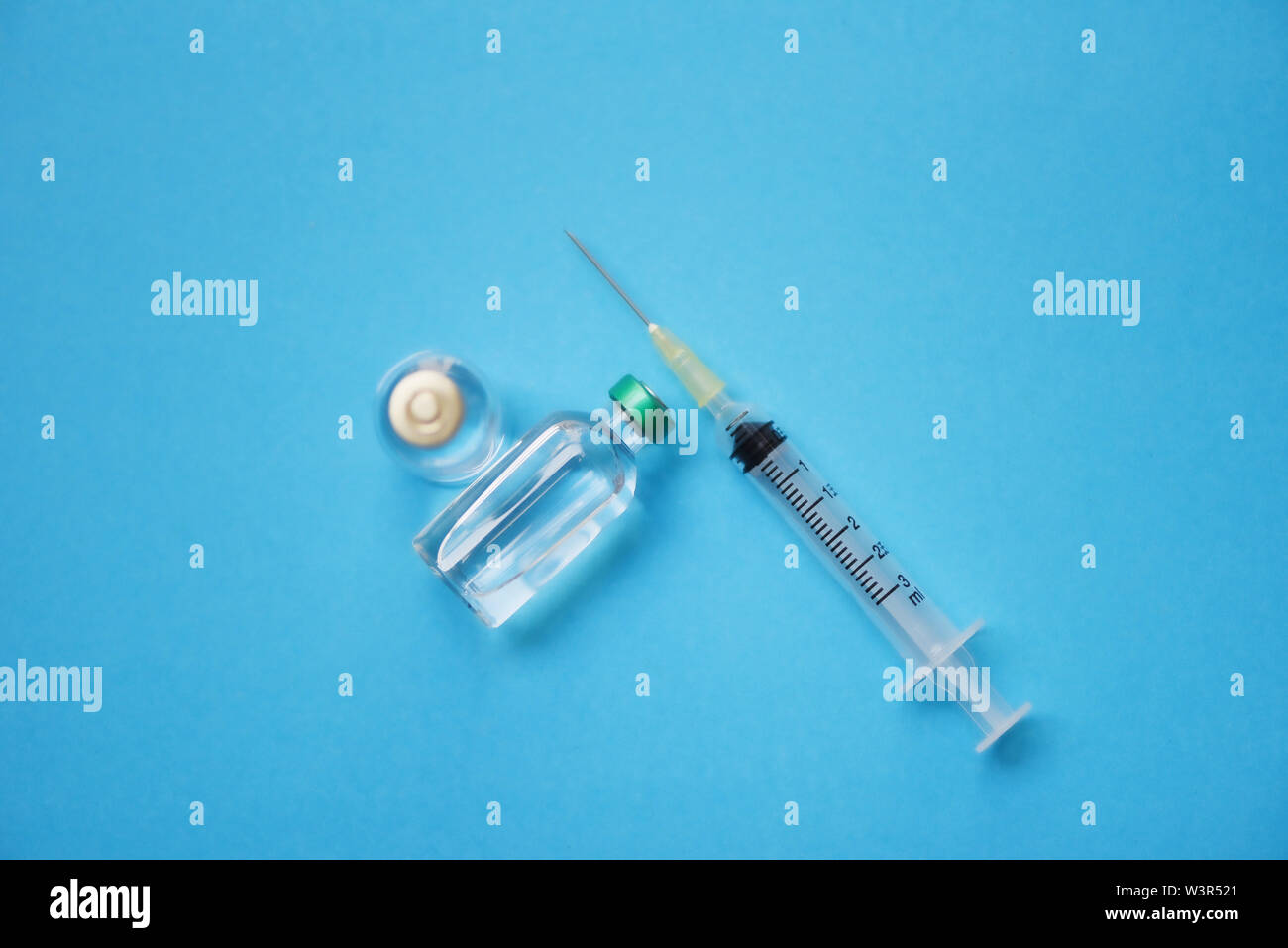 Medicine bottles glass and syringe injection needle on blue background ...